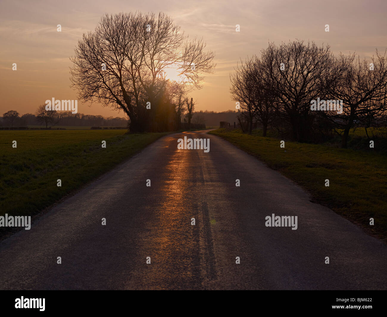 road with sun setting Stock Photo - Alamy
