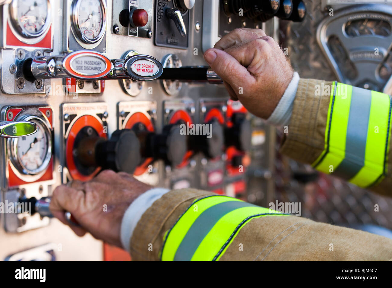 Fire fighter working controls on fire truck Stock Photo - Alamy