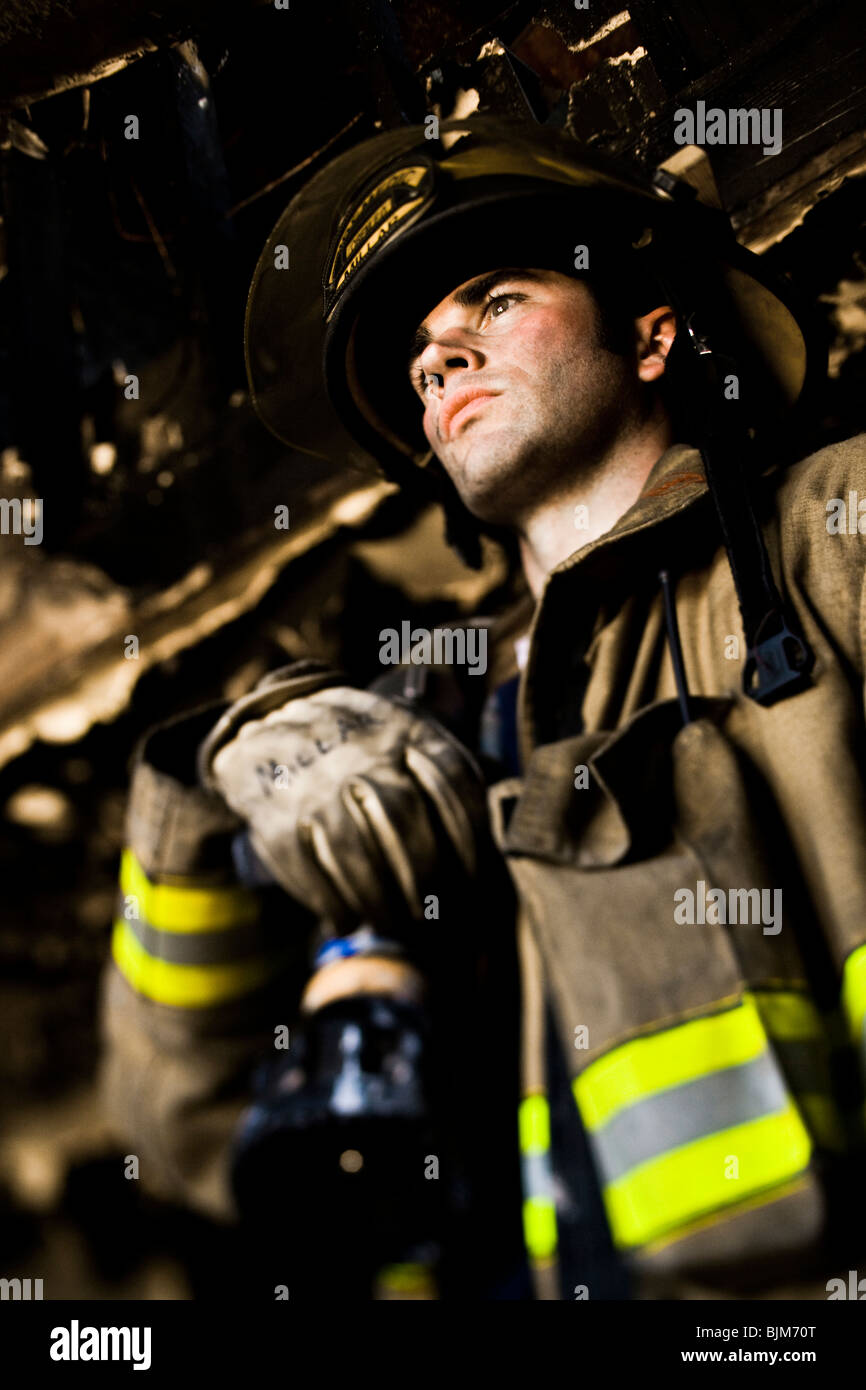 Portrait of a firefighter with fire hose Stock Photo - Alamy