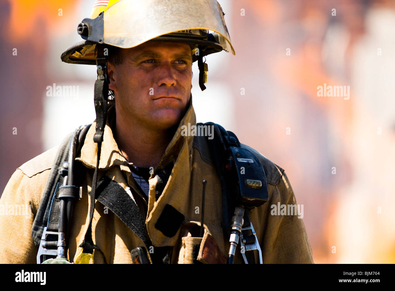 Portrait of a firefighter with fire in background Stock Photo - Alamy