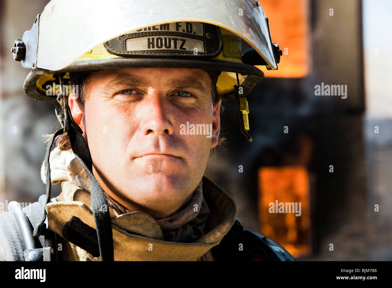 Portrait of a firefighter with fire in background Stock Photo - Alamy