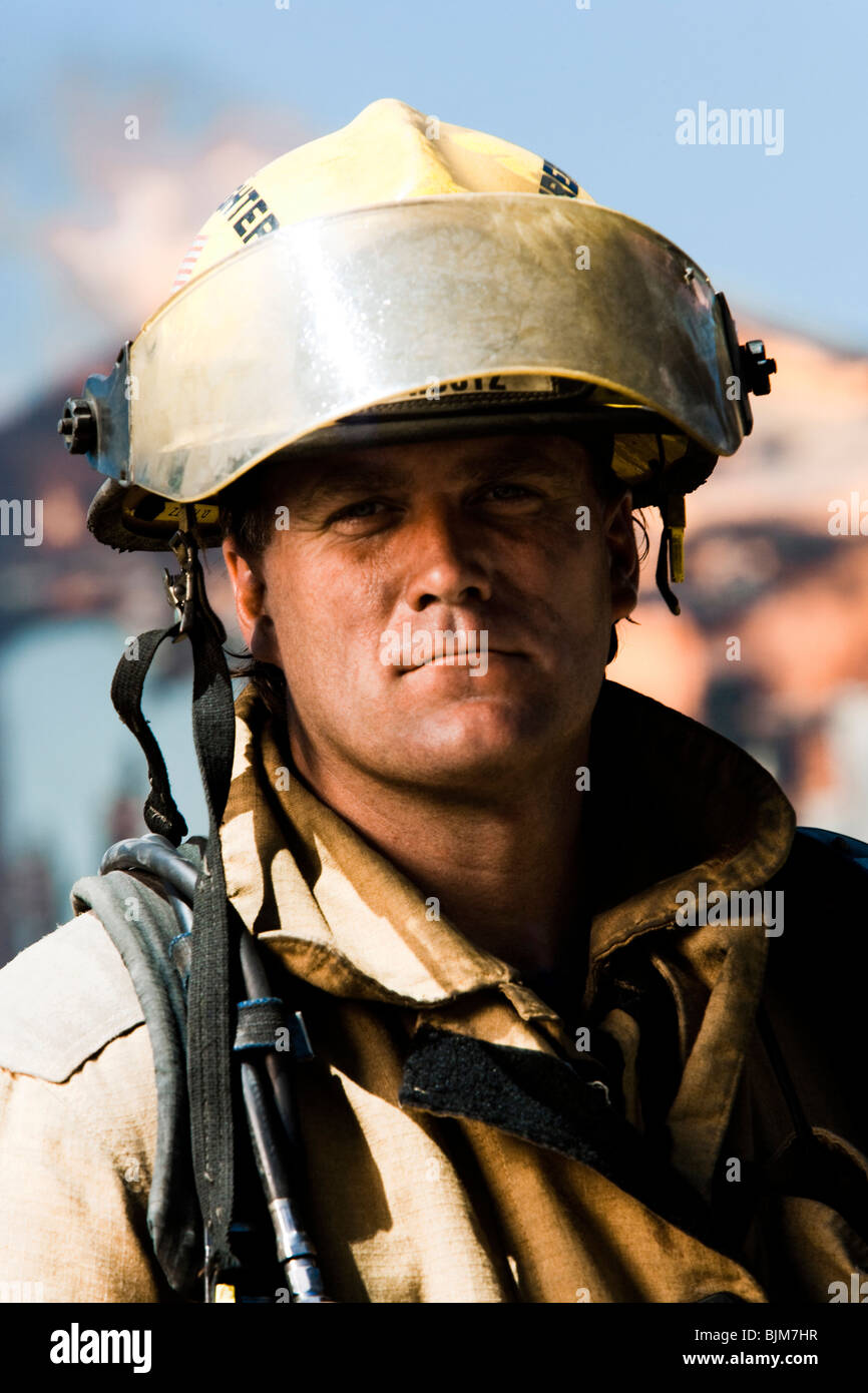 Portrait of a firefighter with fire in background Stock Photo - Alamy