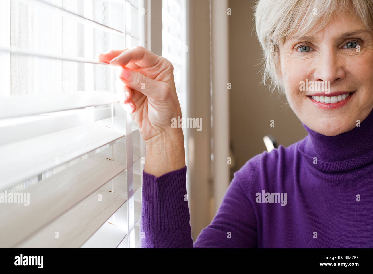 Mature woman at window Stock Photo - Alamy
