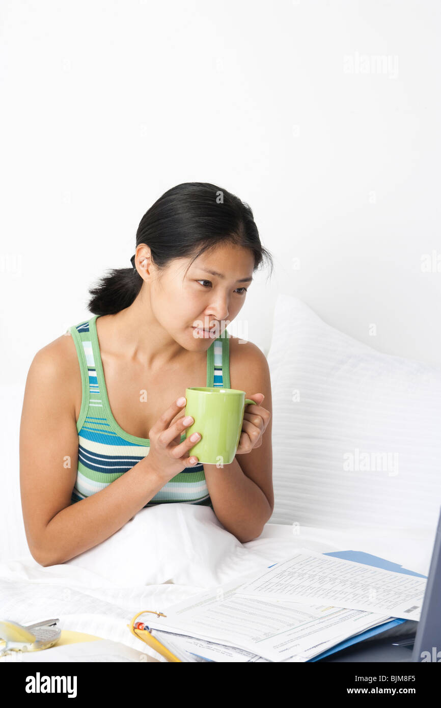 Female working from bed Stock Photo - Alamy