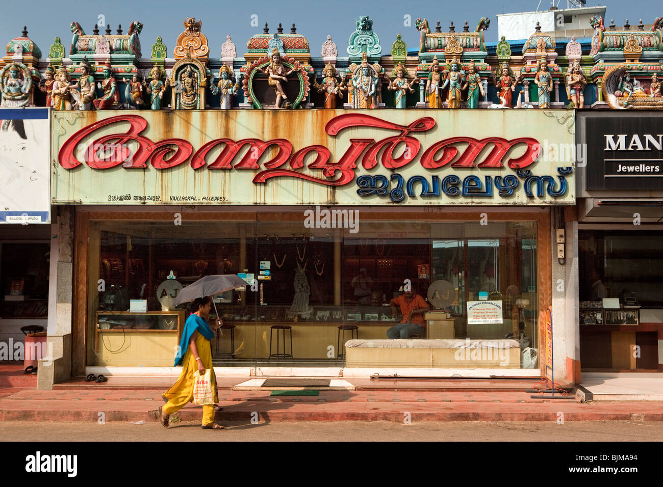 India, Kerala, Alappuzha, (Alleppey), YMCA Road, woman using parasol ...