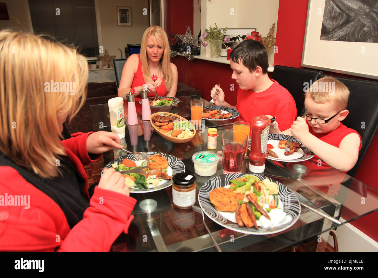 Family eating dinner round the table Stock Photo - Alamy