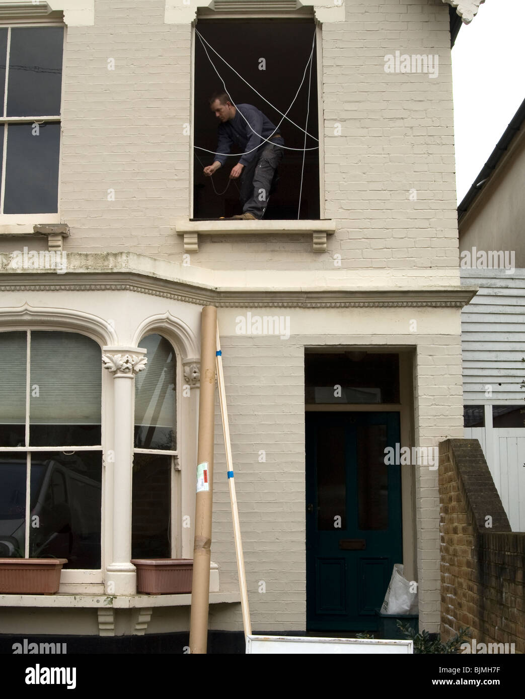 Workman refurbishing original sash window in Victorian/Edwardian house ...