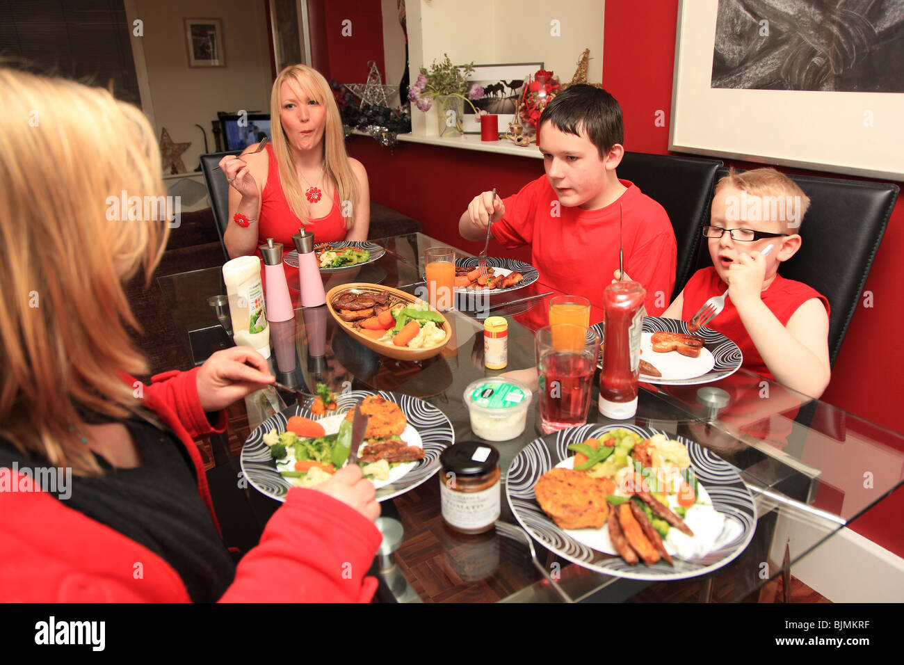 Family eating dinner round the table Stock Photo - Alamy