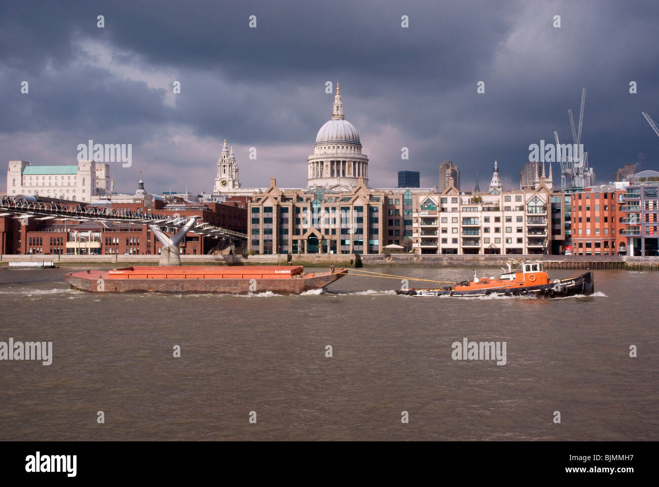 River Thames tug and barge pass under the Millenium Bridge Stock Photo ...