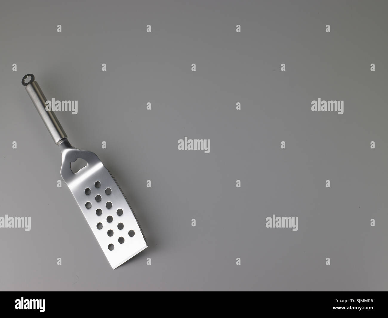 barbecue cutlery on grey background showing serrated burger flipper ...