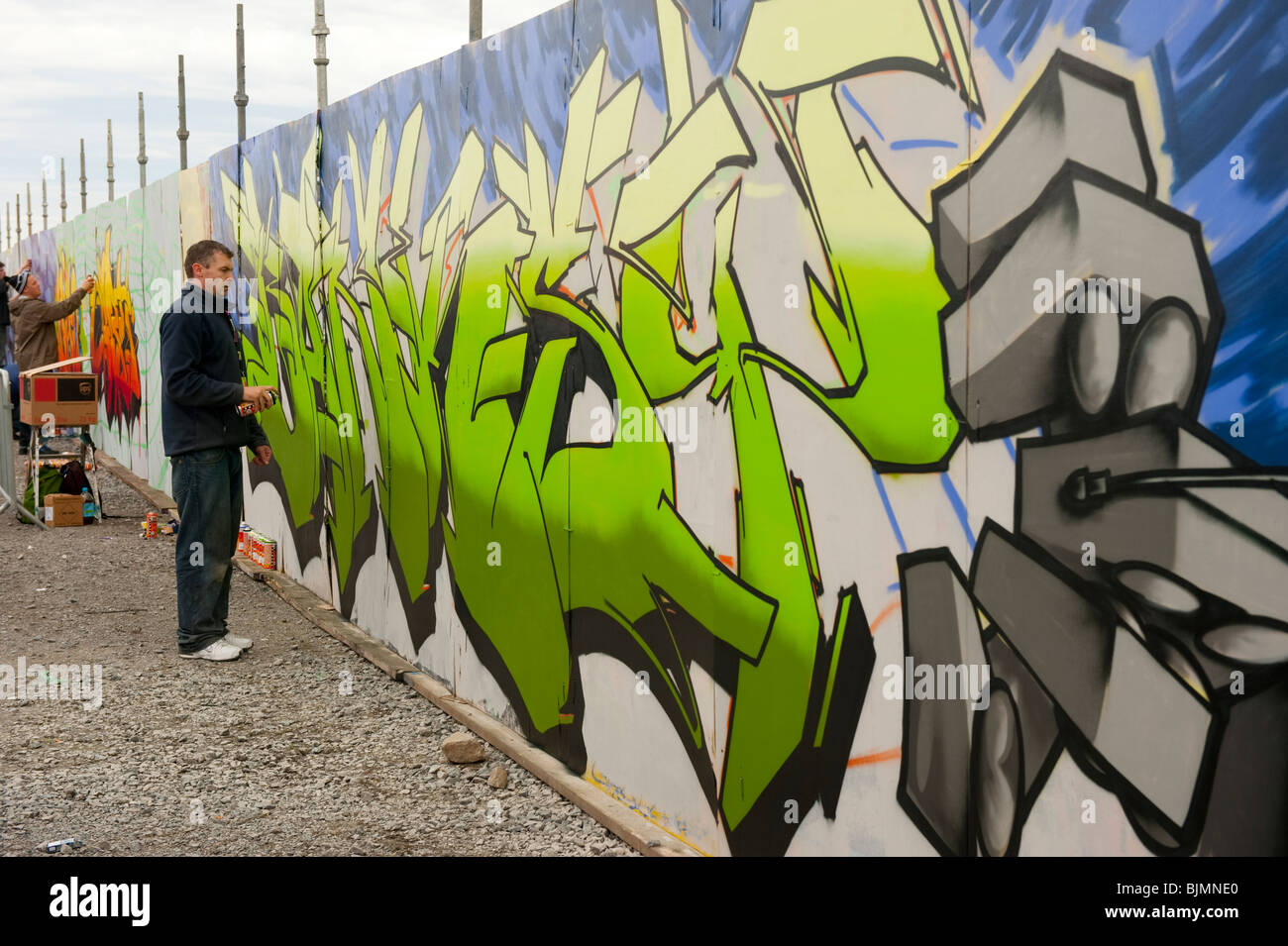 Graffiti artist painting design on wall Stock Photo - Alamy