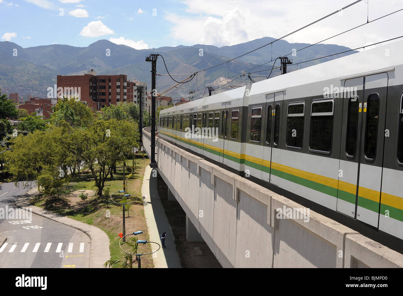Metro traveling on rail track alongside road. Medellin, Colombia Stock ...