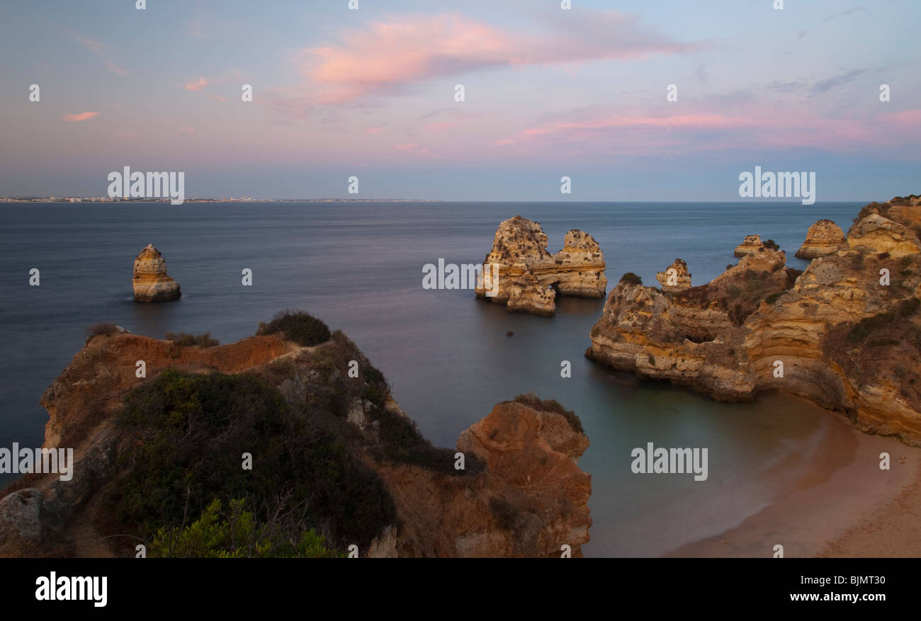 Rocks in the sea and the beach on the coast of the Algarve in Portugal ...