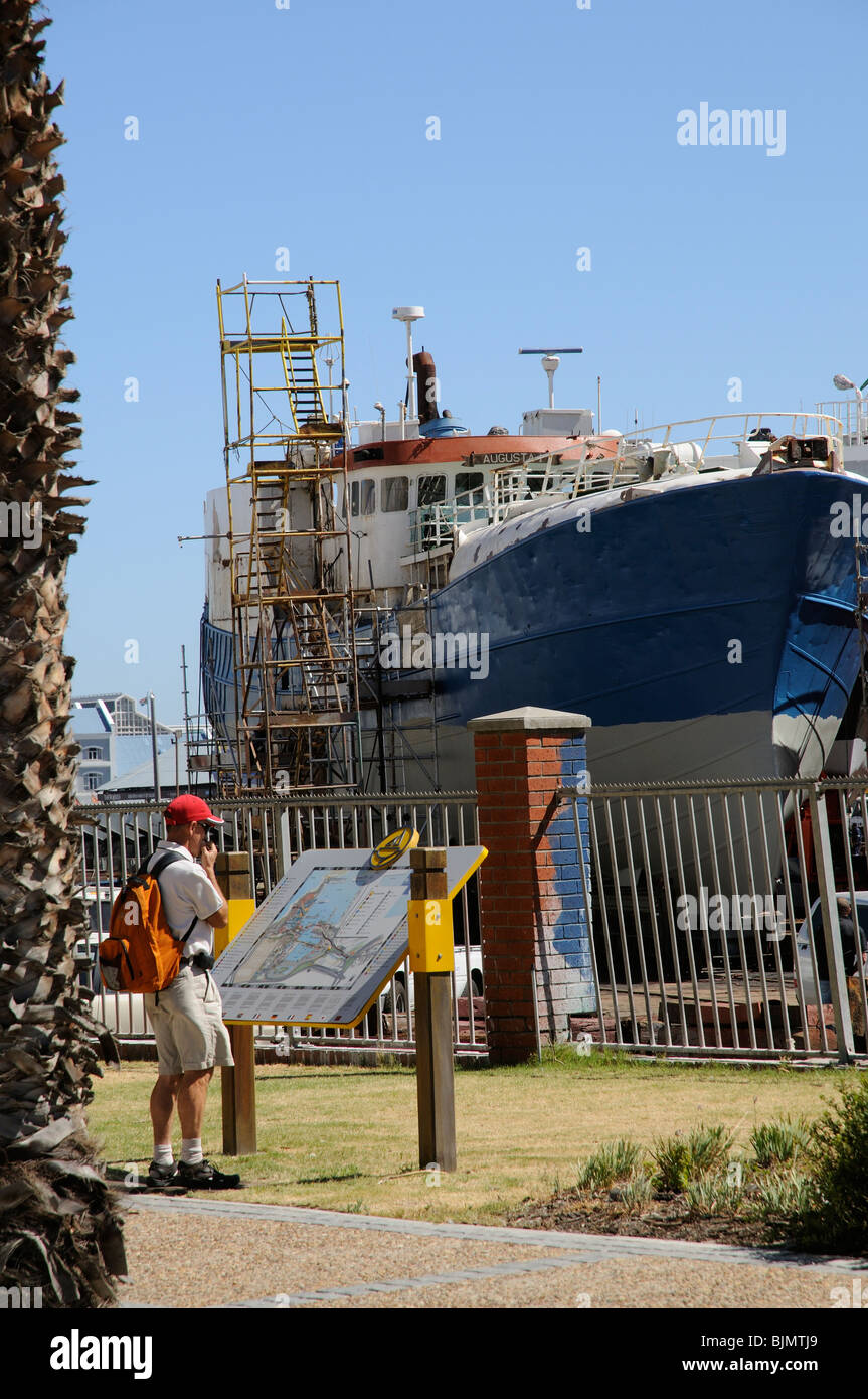 Tourist reading a map during a walking tour of ship painting and ...