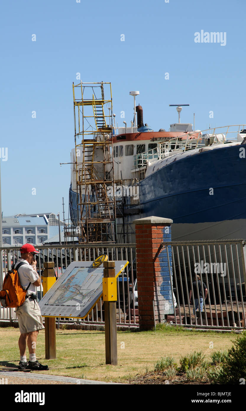 Tourist reading a map during a walking tour of ship painting and ...