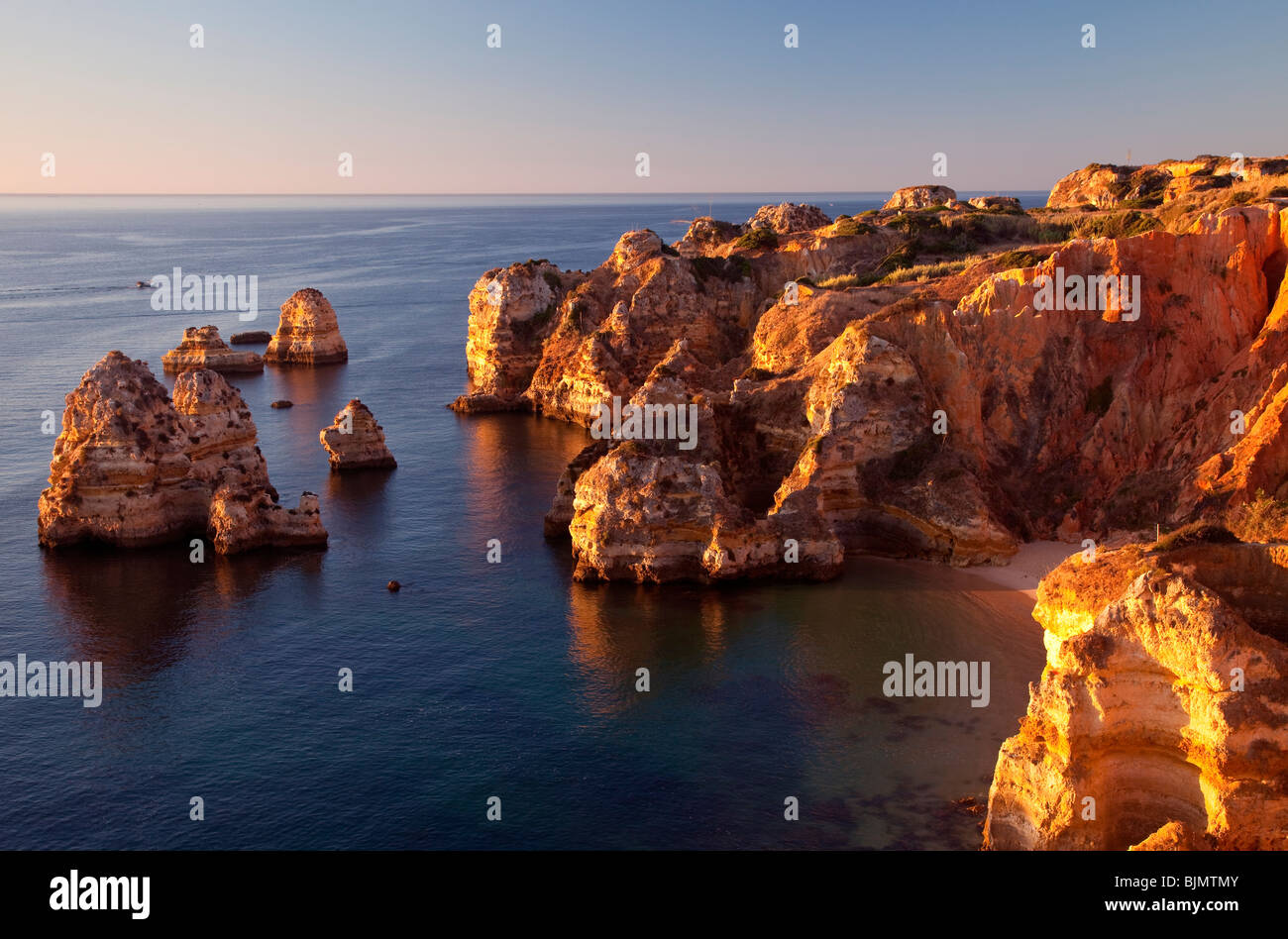 Rocks in the sea and the beach at sunrise in Algarve at Portugal Stock ...