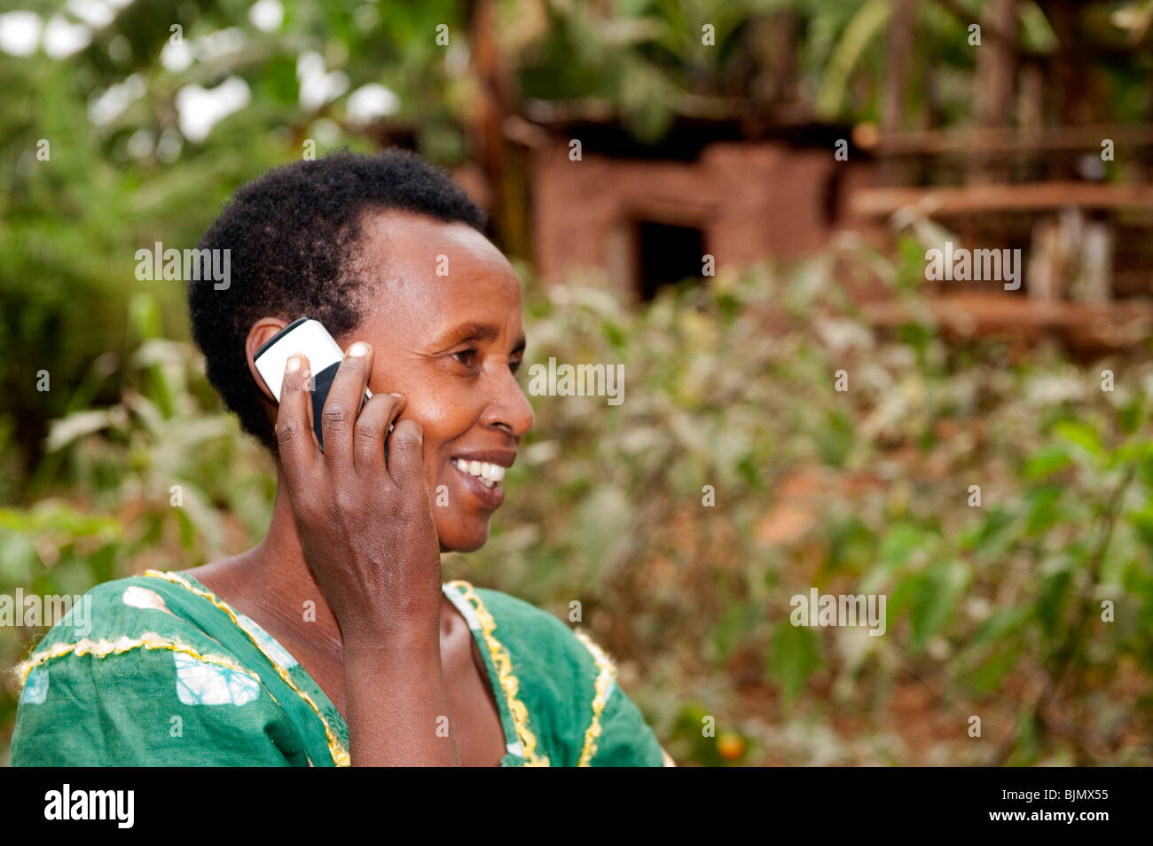 Rwandan Lady on a mobile phone while working in garden. Rwanda Stock ...