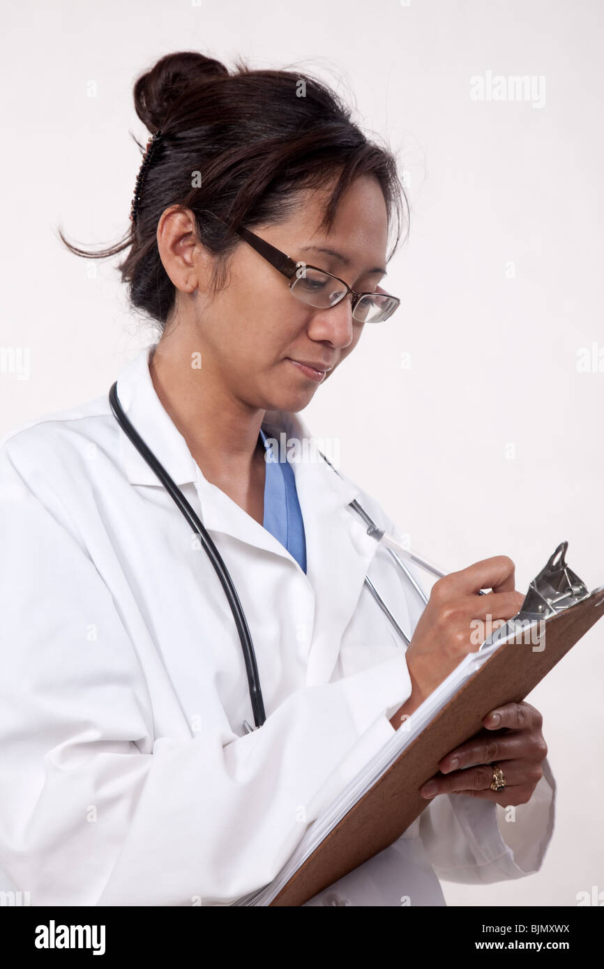Asian doctor physician writing on clipboard Stock Photo - Alamy