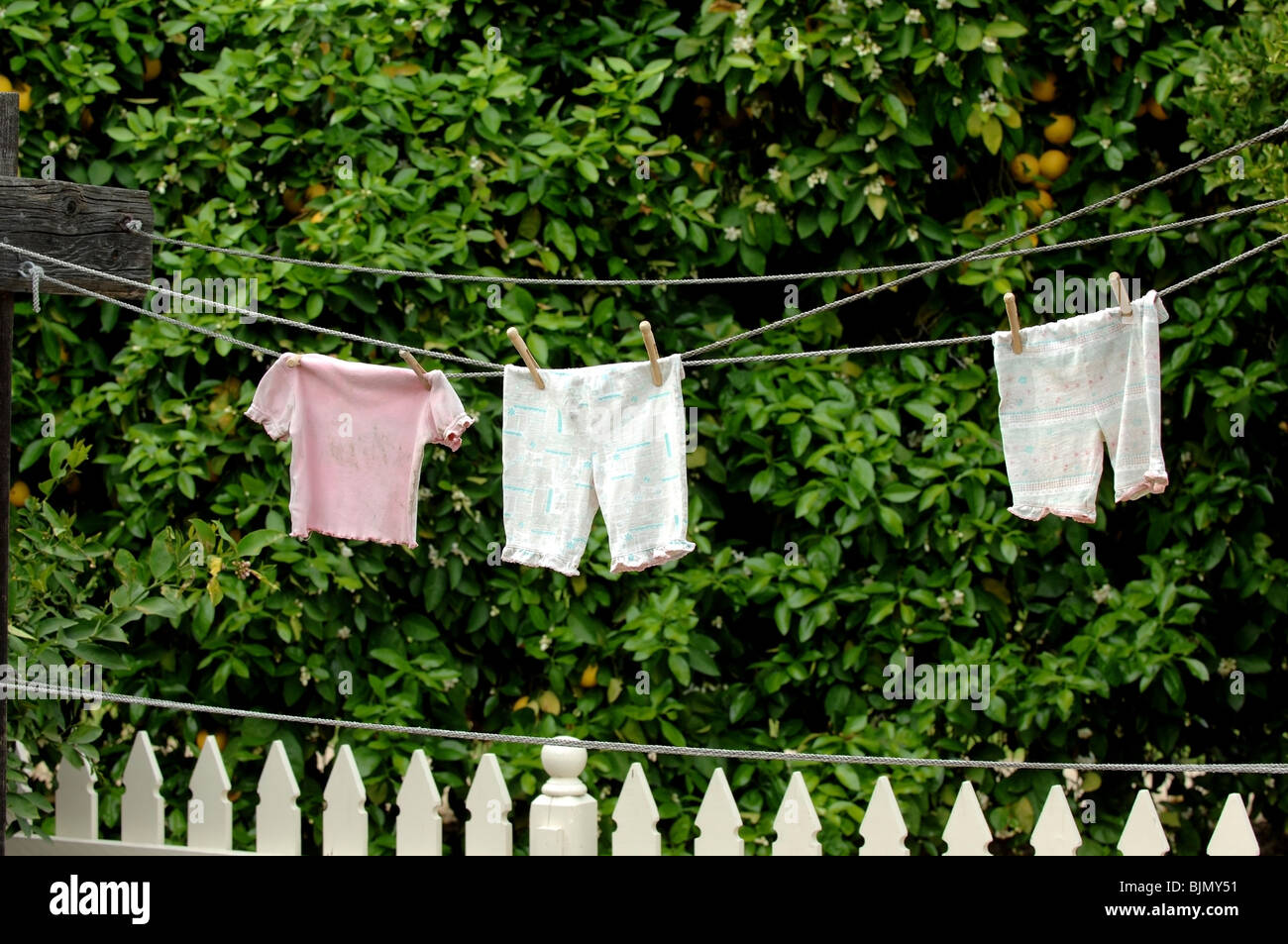Vintage children's clothing drying on a clothes line with held with ...