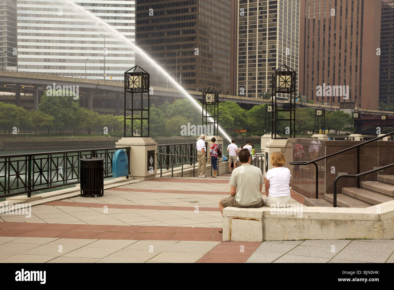 Couple sitting on Chicago Riverwalk near Centennial Fountain Stock ...