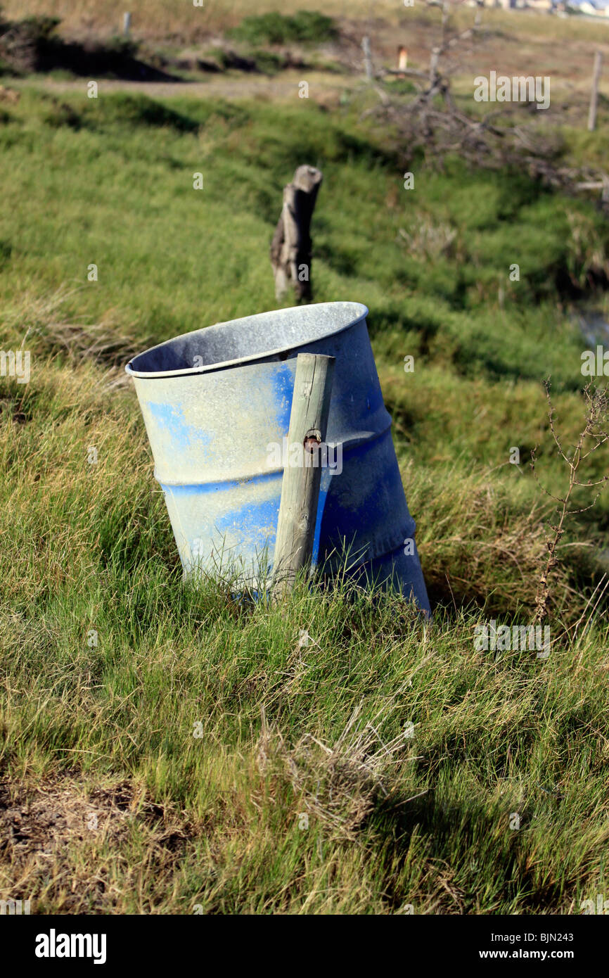 Rusty blue rubbish bin in green field Stock Photo - Alamy