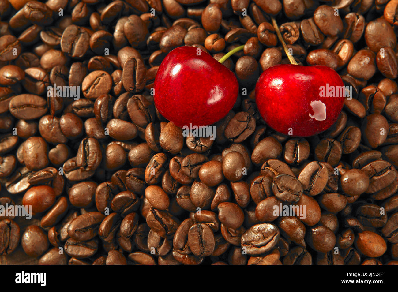 Toasted coffee beans texture and red cherry fruits Stock Photo - Alamy