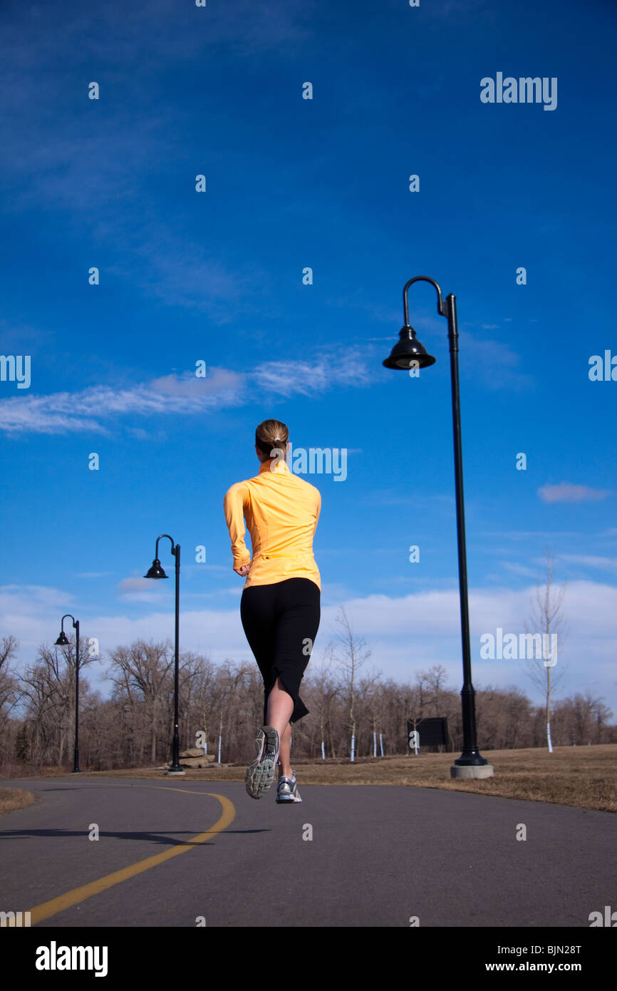 Young woman jogging outdoors on city pathway Stock Photo - Alamy