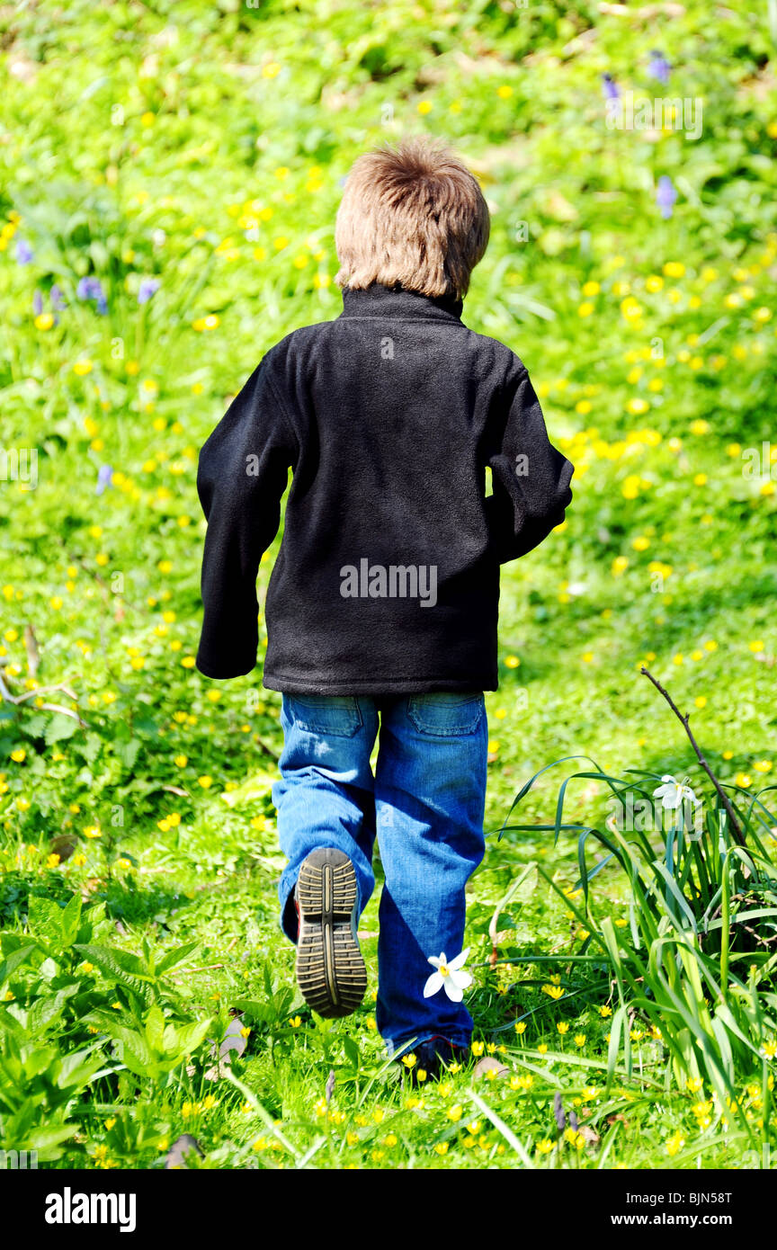 Vertical image of a boy running in a field Stock Photo - Alamy