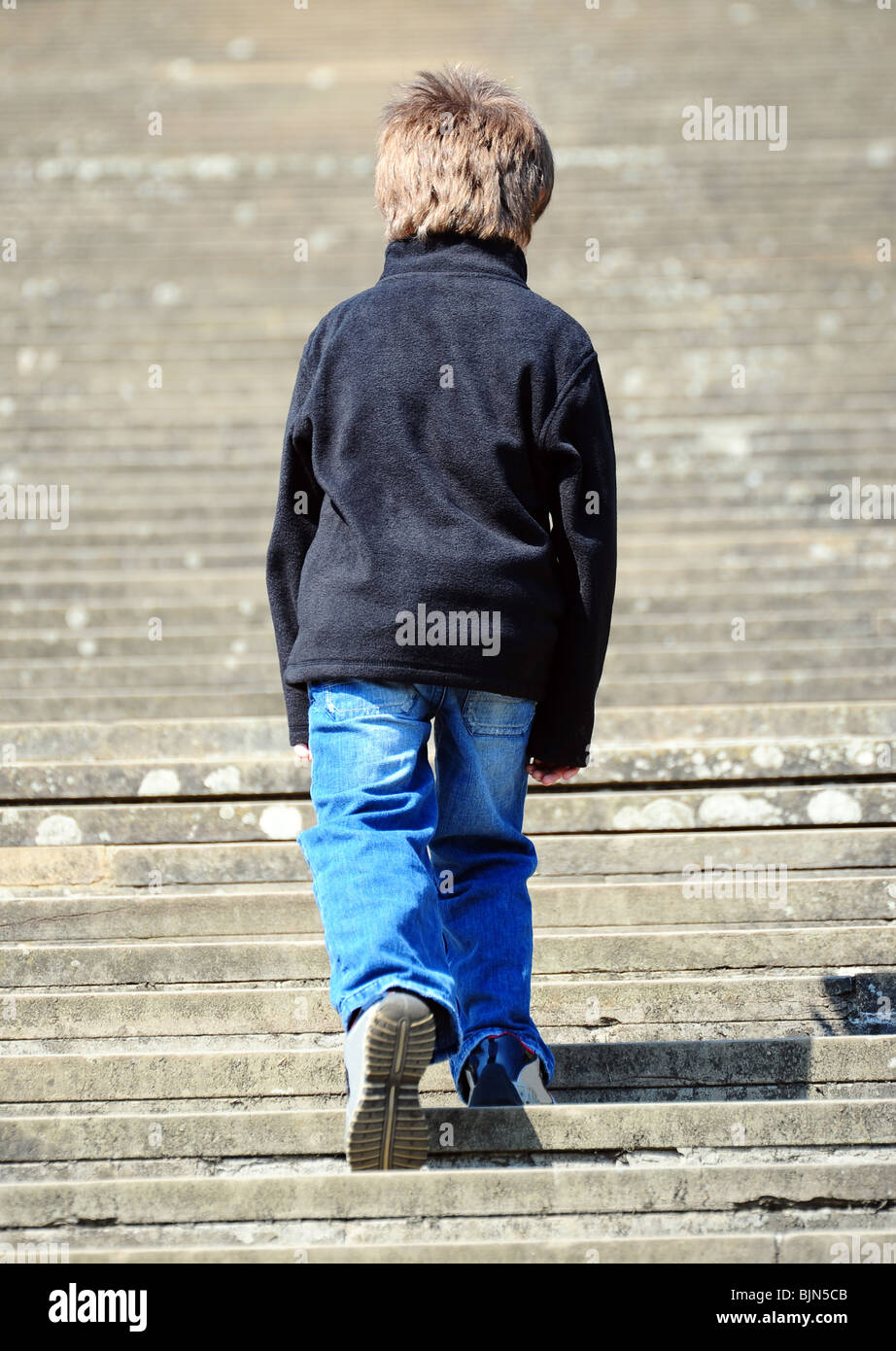 Vertical image of a boy walking up some steps Stock Photo - Alamy