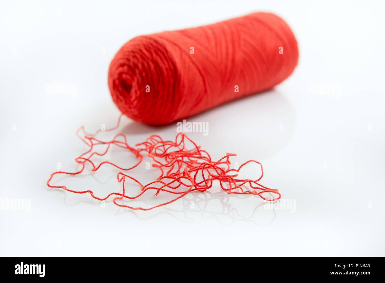 Red thread spool isolated over white studio background Stock Photo - Alamy