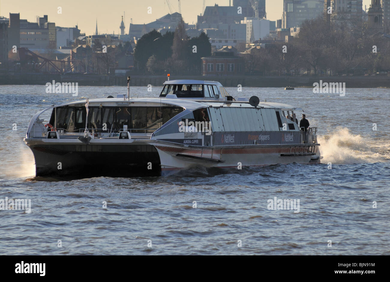 Thames clipper riverboat approaching Canary Wharf pier jetty , London ...