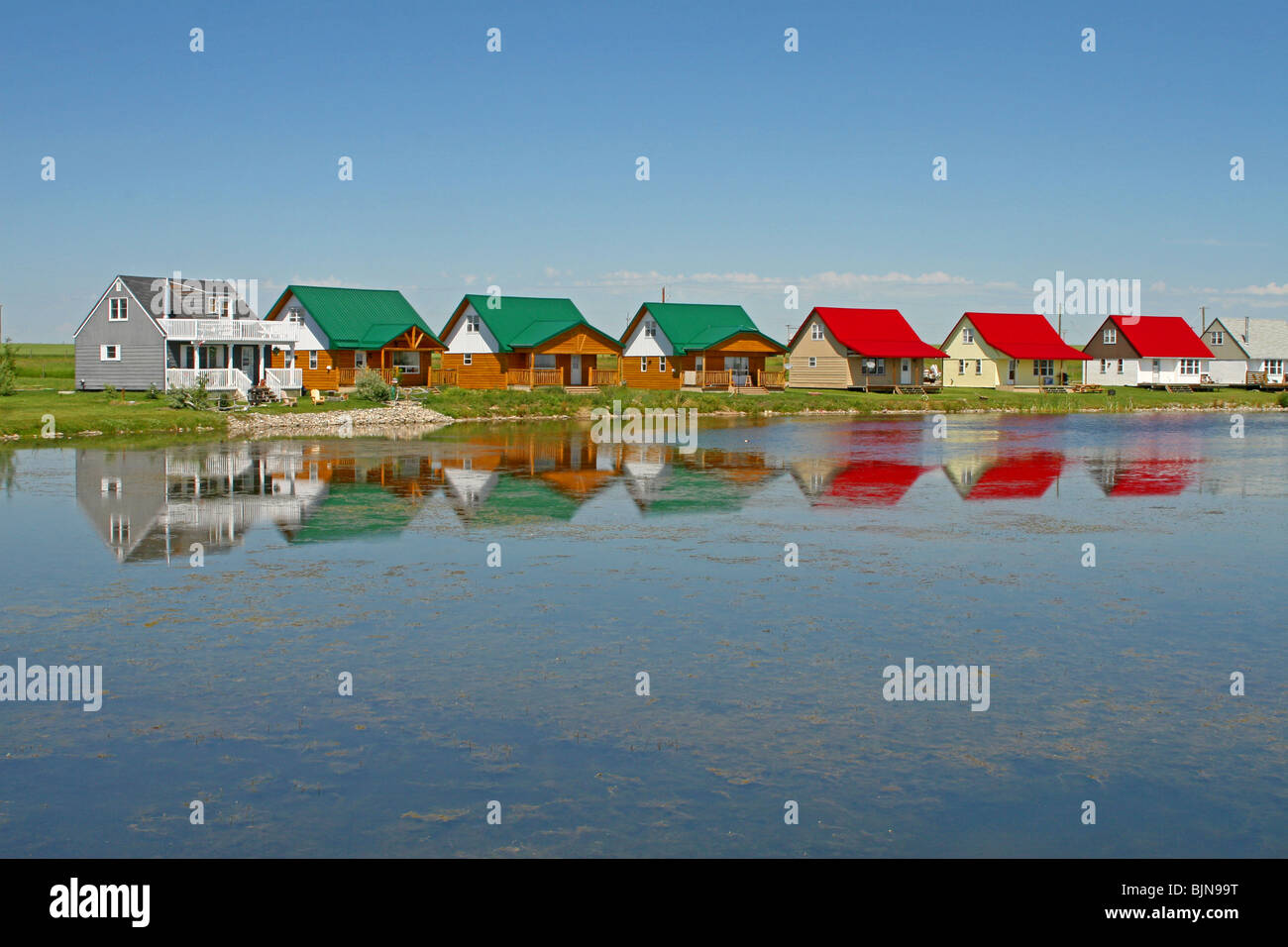 Colorful cabins reflected in a lake Stock Photo - Alamy