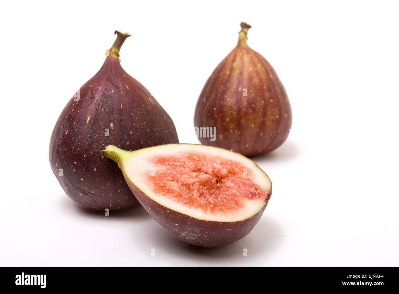 Figs one halved isolated against white background Stock Photo - Alamy