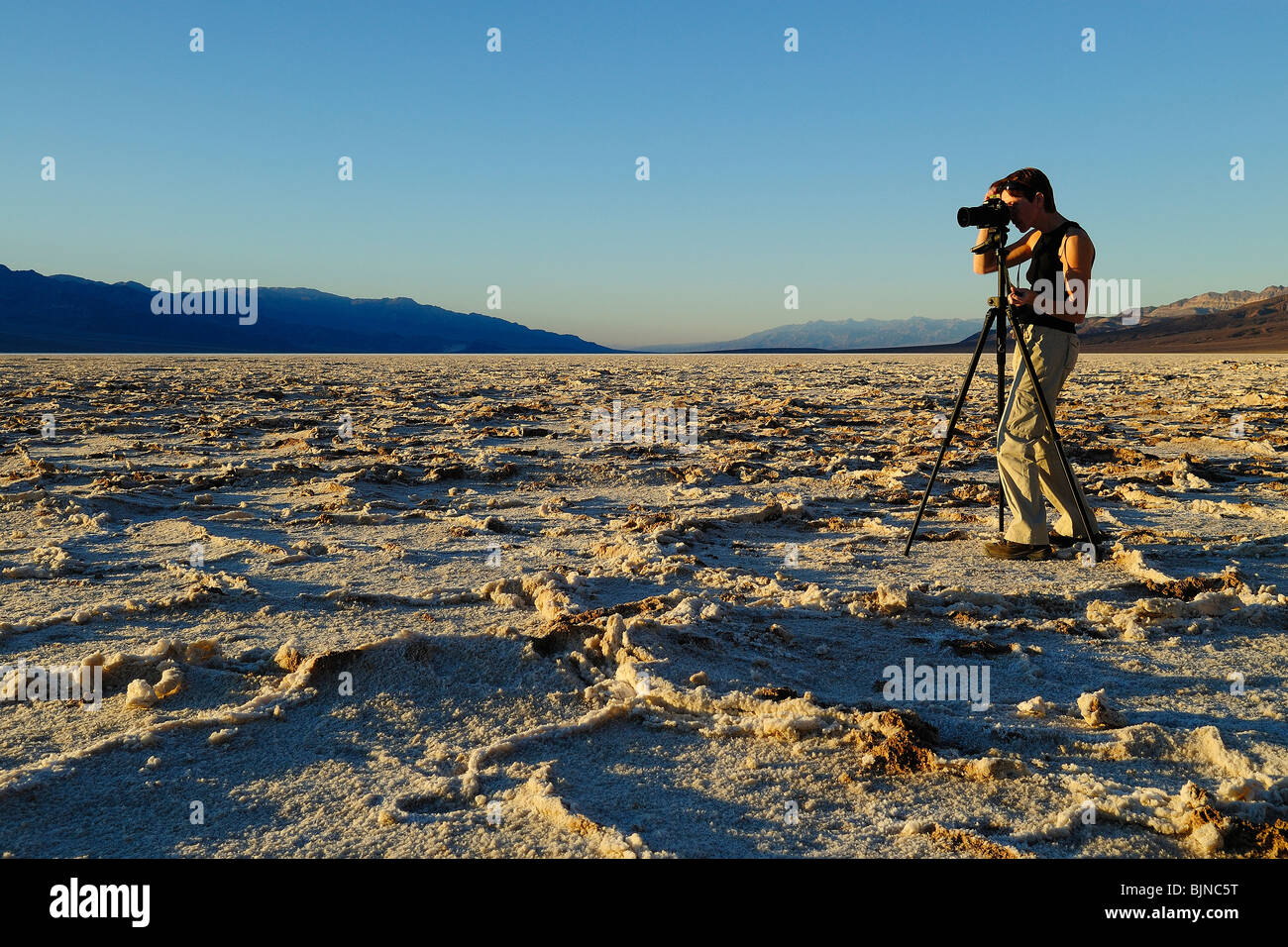 Photographer at salt pools in Badwater in Death Valley, California ...