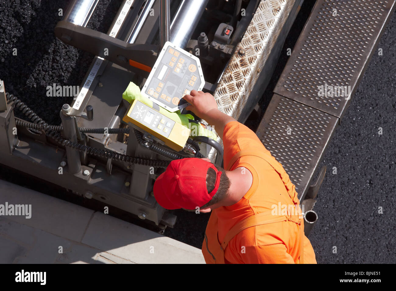 Man working on control panel asphalt machine Stock Photo - Alamy
