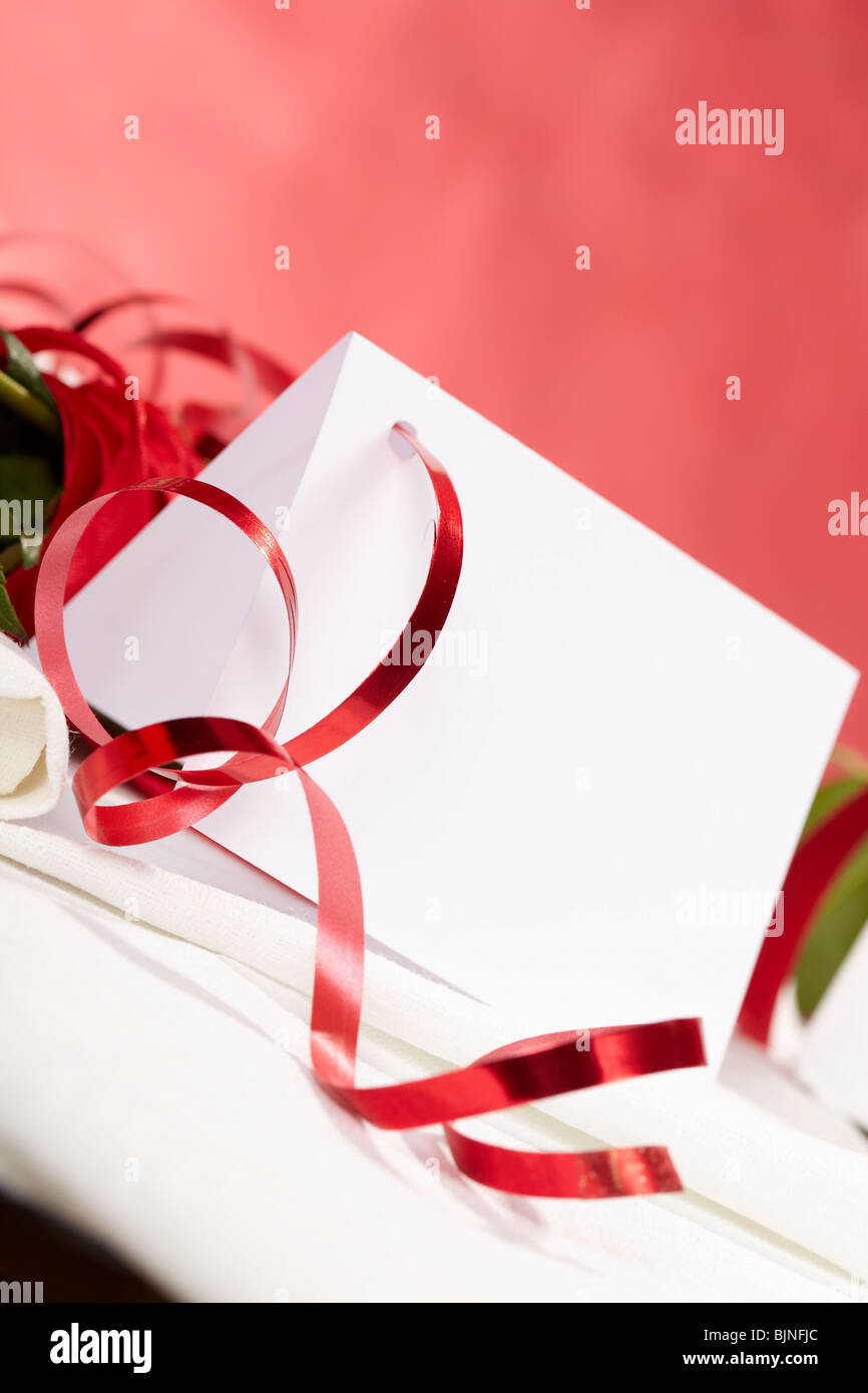 white card note with red ribbon Stock Photo - Alamy