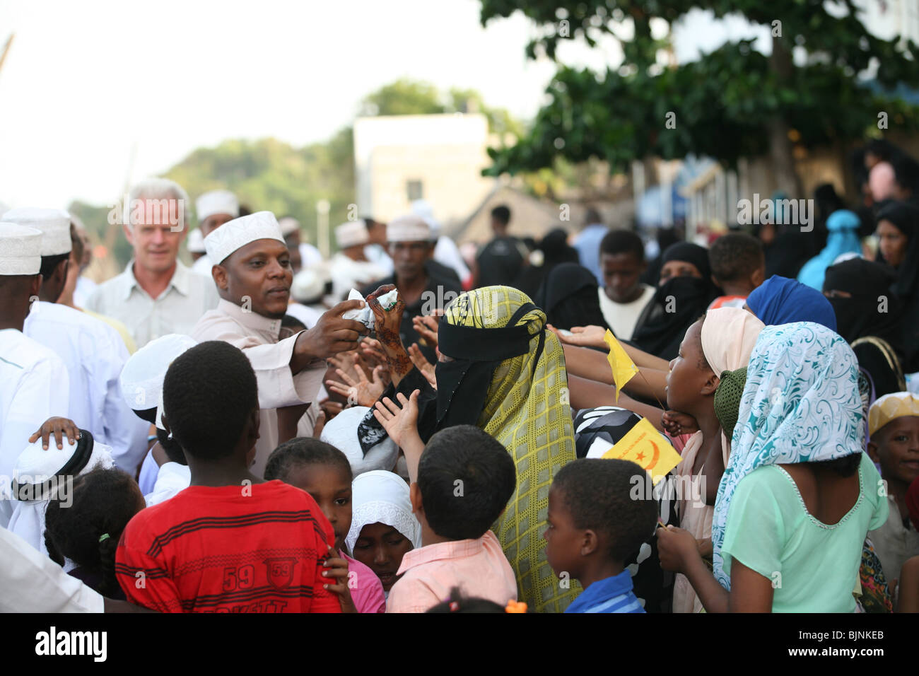 Swahili women some wearing traditional dress receiving money during ...