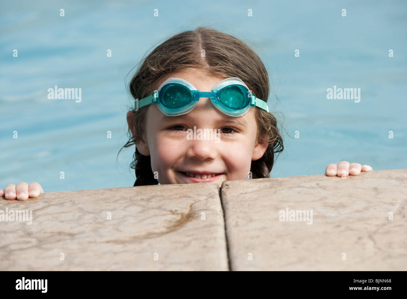 Girl with swimming goggles by pool Stock Photo - Alamy