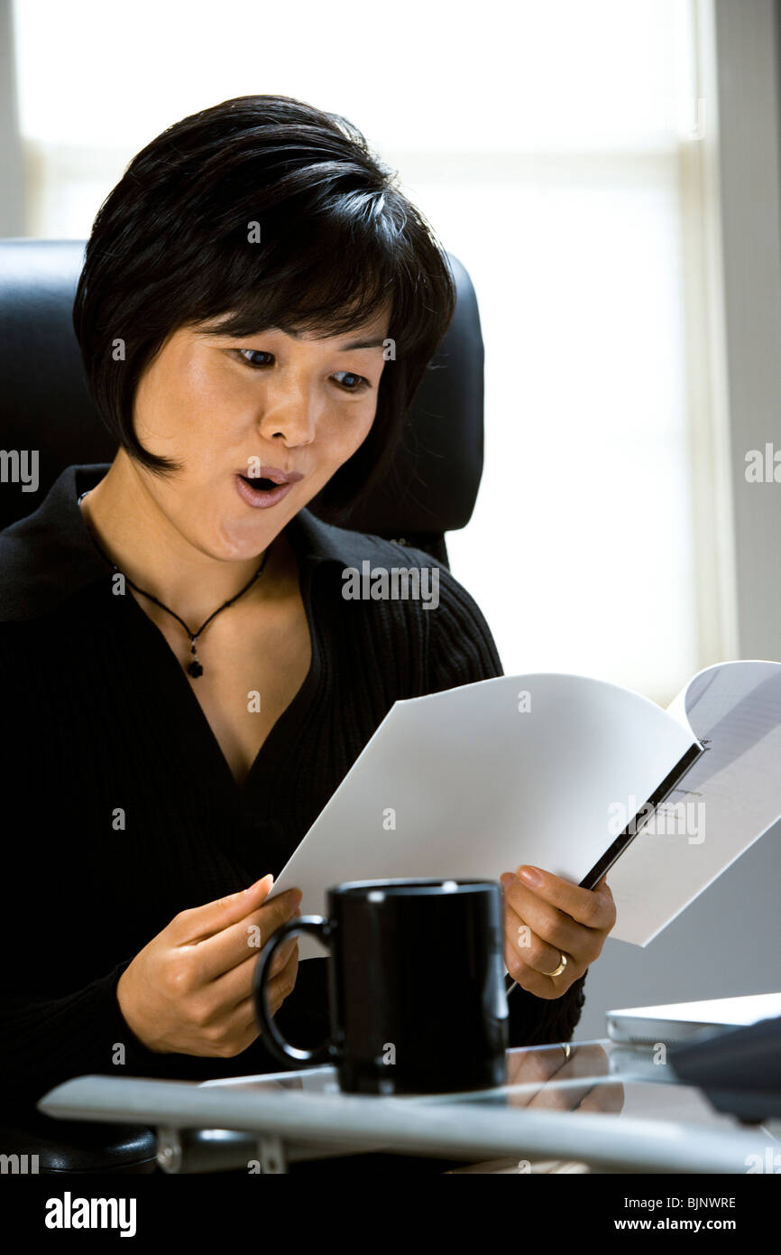 Woman reading a report Stock Photo - Alamy