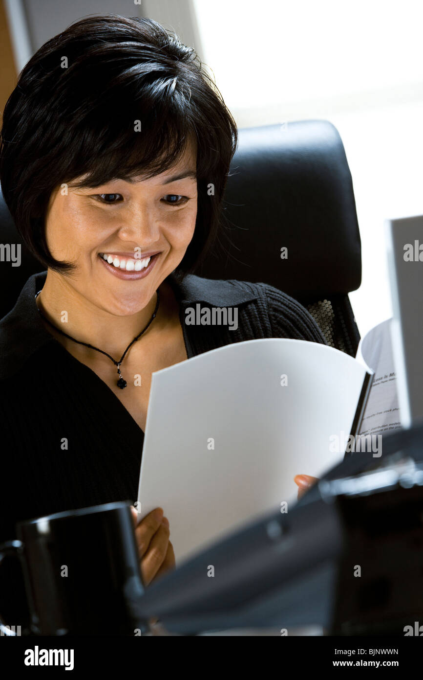 Woman reading a report Stock Photo - Alamy