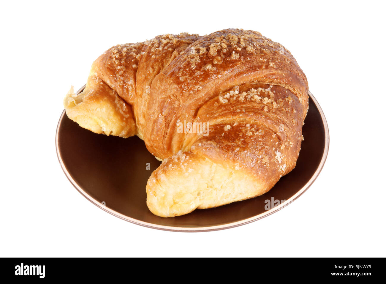 Croissant with sugar served on a brown side plate, isolated on white ...
