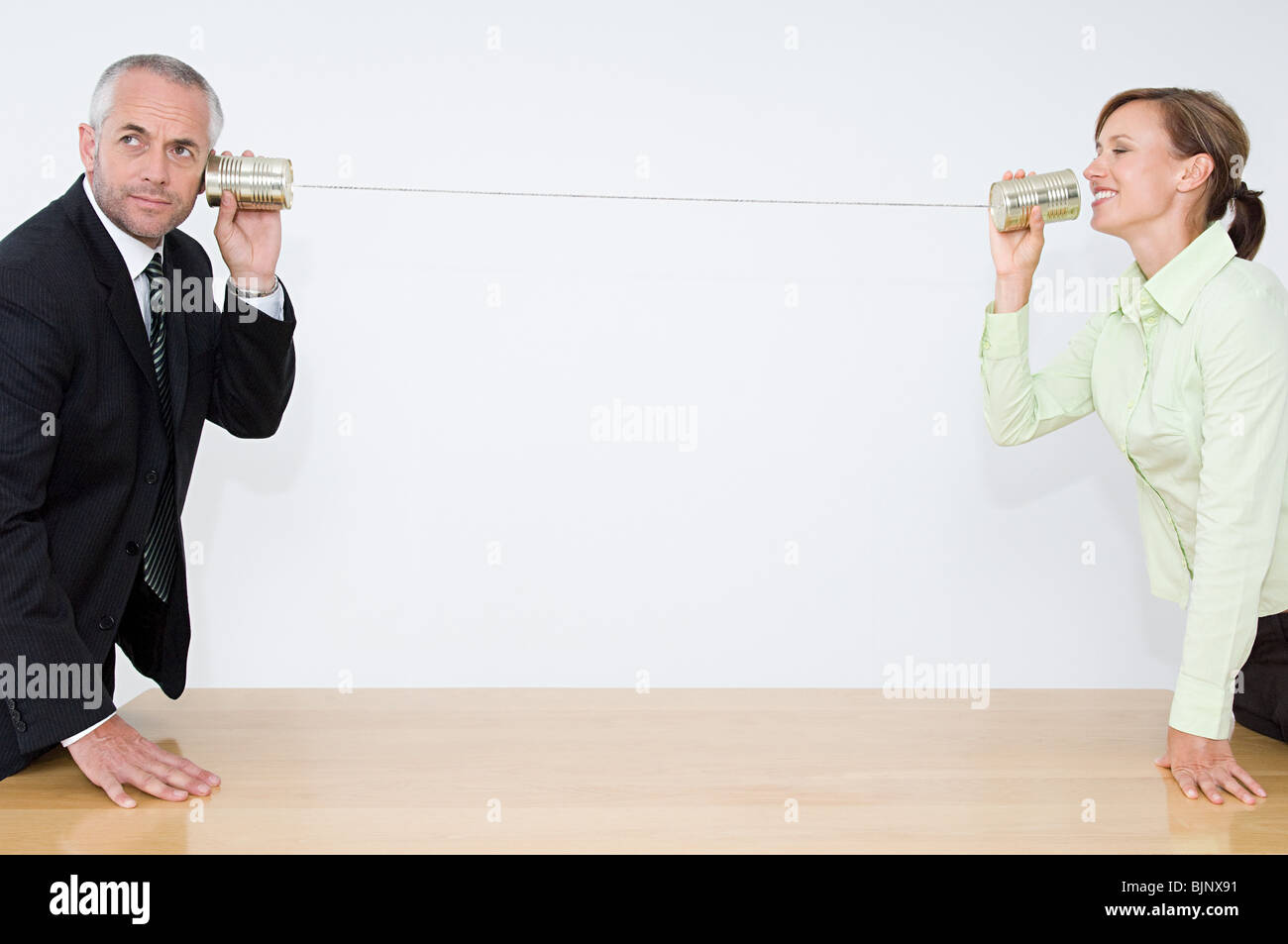 Businesspeople using a tin can telephone Stock Photo - Alamy