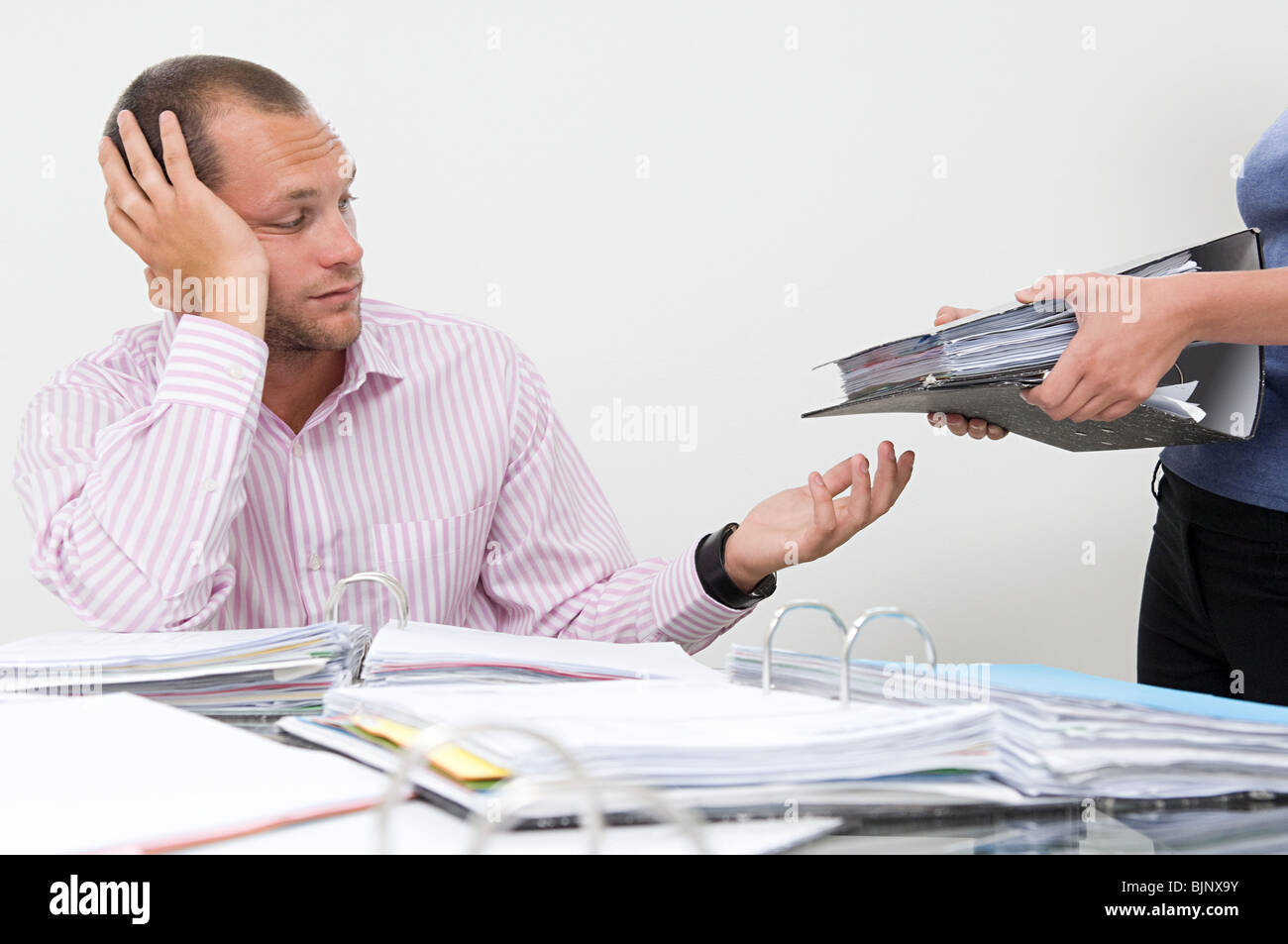 A businessman being given more work Stock Photo - Alamy
