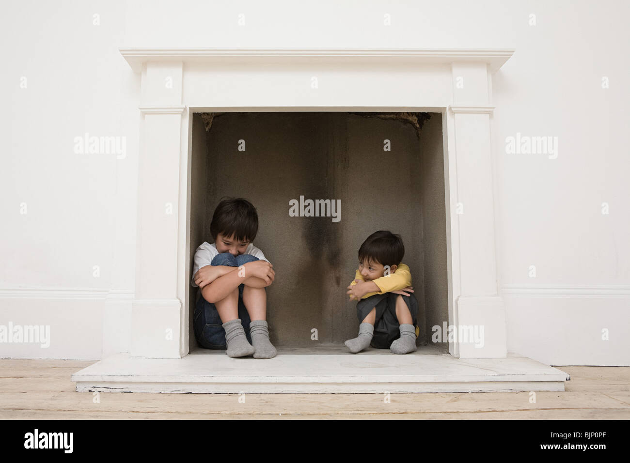 Boys hiding in a fireplace Stock Photo - Alamy