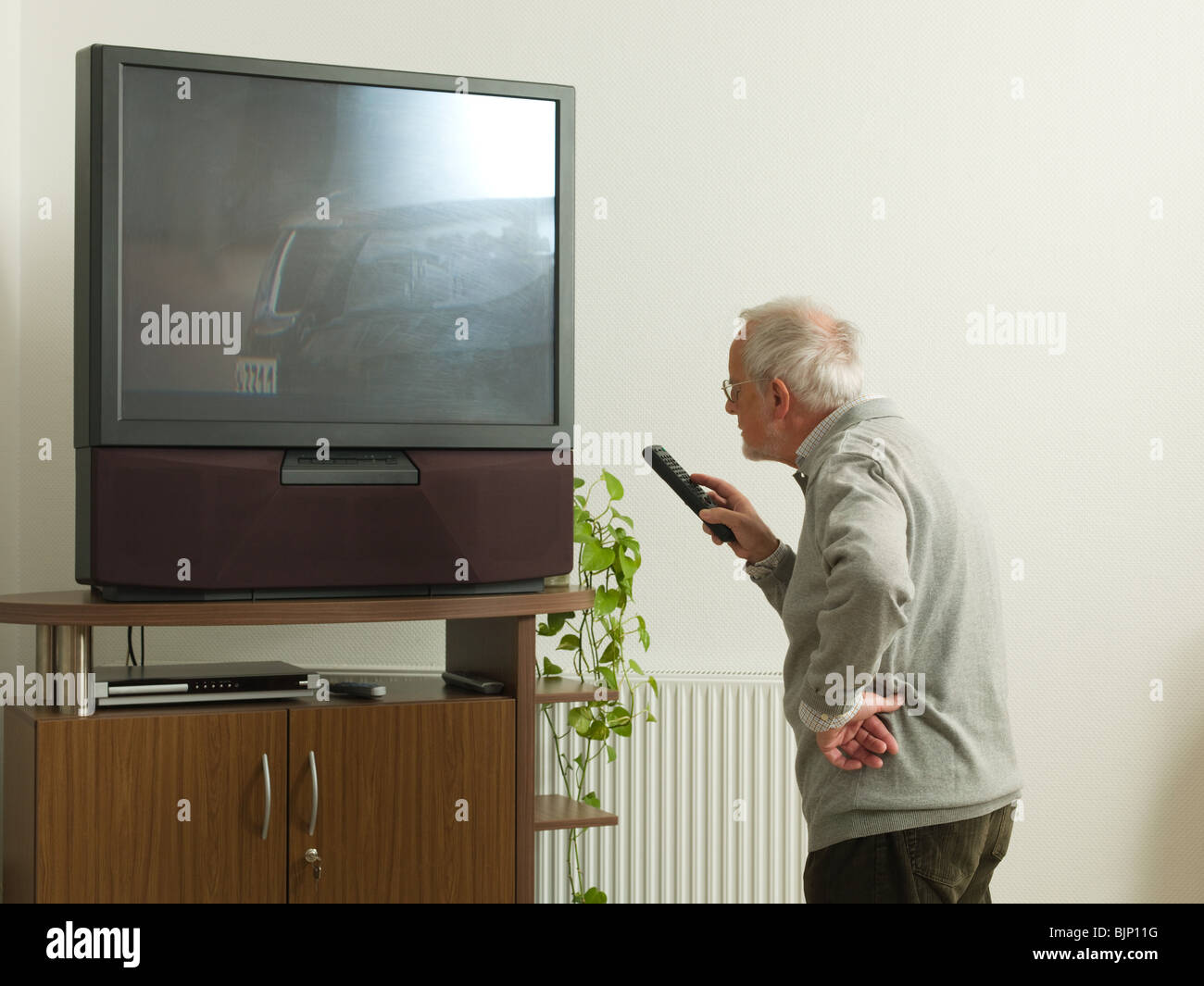 Senior man confused by large television Stock Photo - Alamy