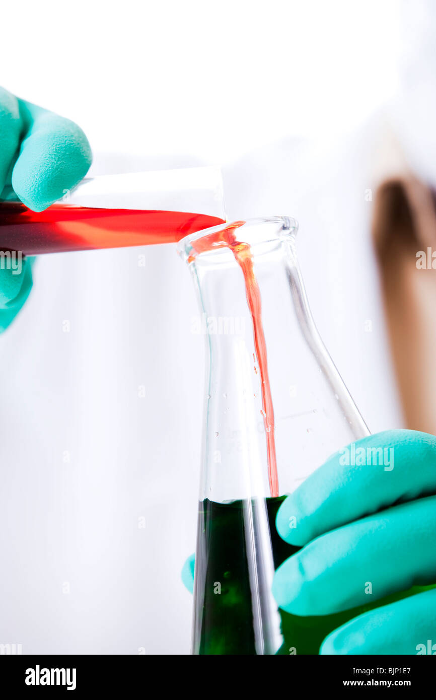 Closeup of scientist pouring chemicals into beaker Stock Photo - Alamy