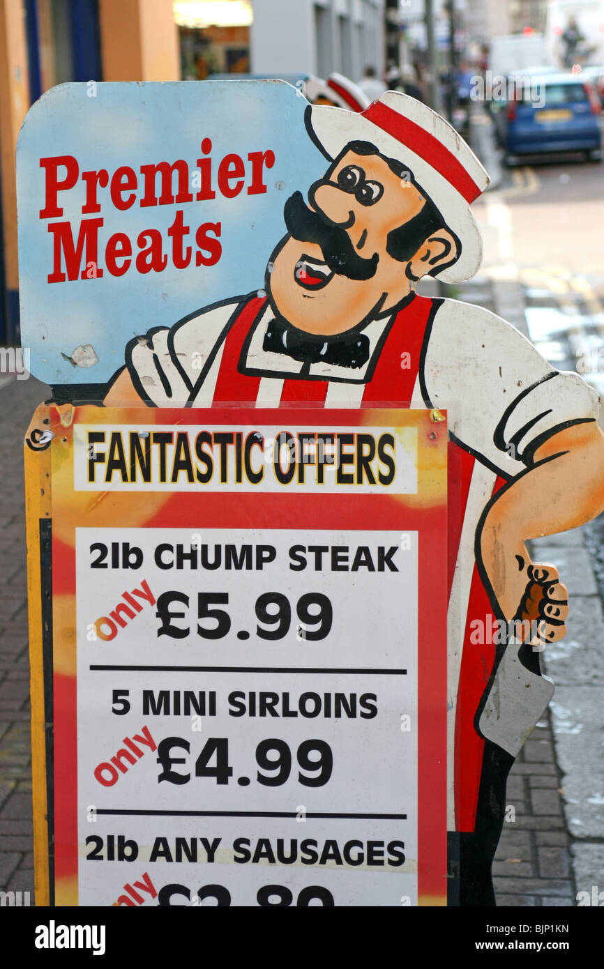 a cut out advert outside a butchers. a board advertising the price of ...