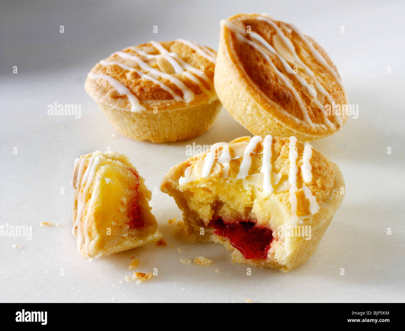 Traditional almond flavoured individual bakewell tarts, on broken open ...