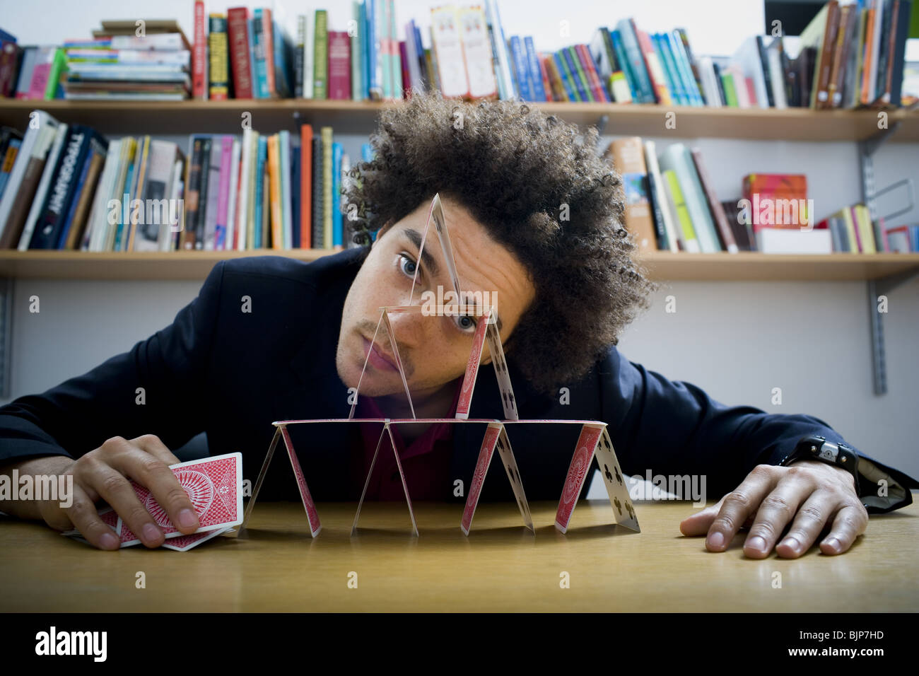Man making a pyramid out of playing cards Stock Photo - Alamy