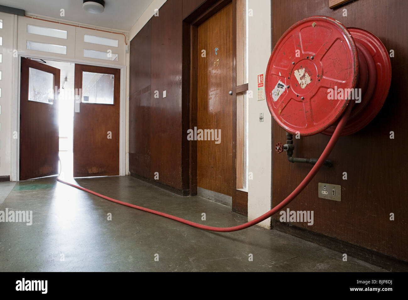Fire hose in corridor Stock Photo - Alamy